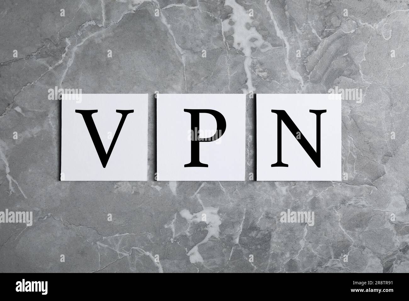 Paper notes with acronym VPN on light grey marble table, flat lay Stock ...