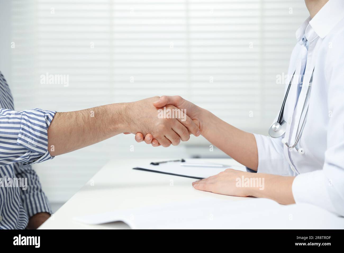 Doctor shaking hands with patient in hospital, closeup Stock Photo - Alamy