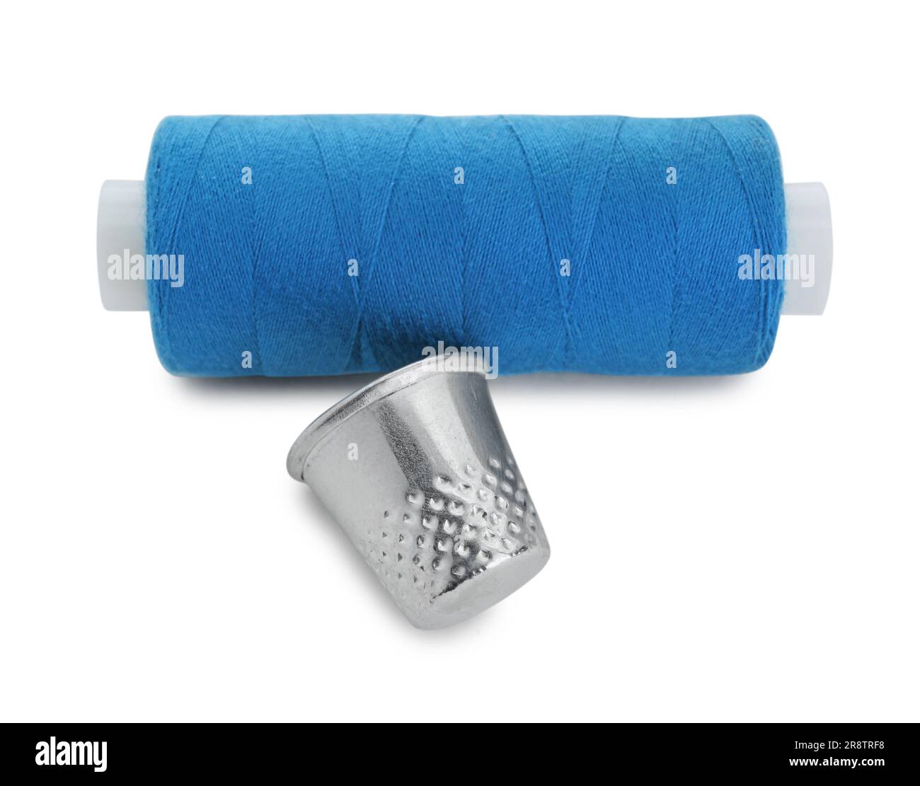 Thimble and spool of blue sewing thread isolated on white, above view ...