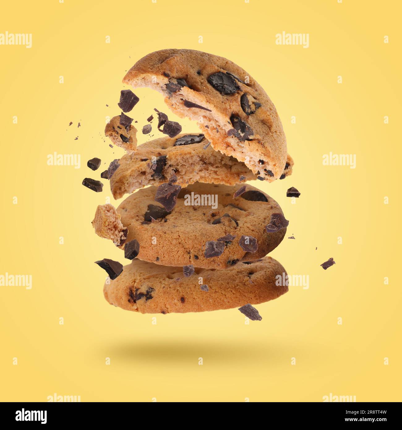 Tasty chocolate chip cookies falling on gold background Stock Photo - Alamy