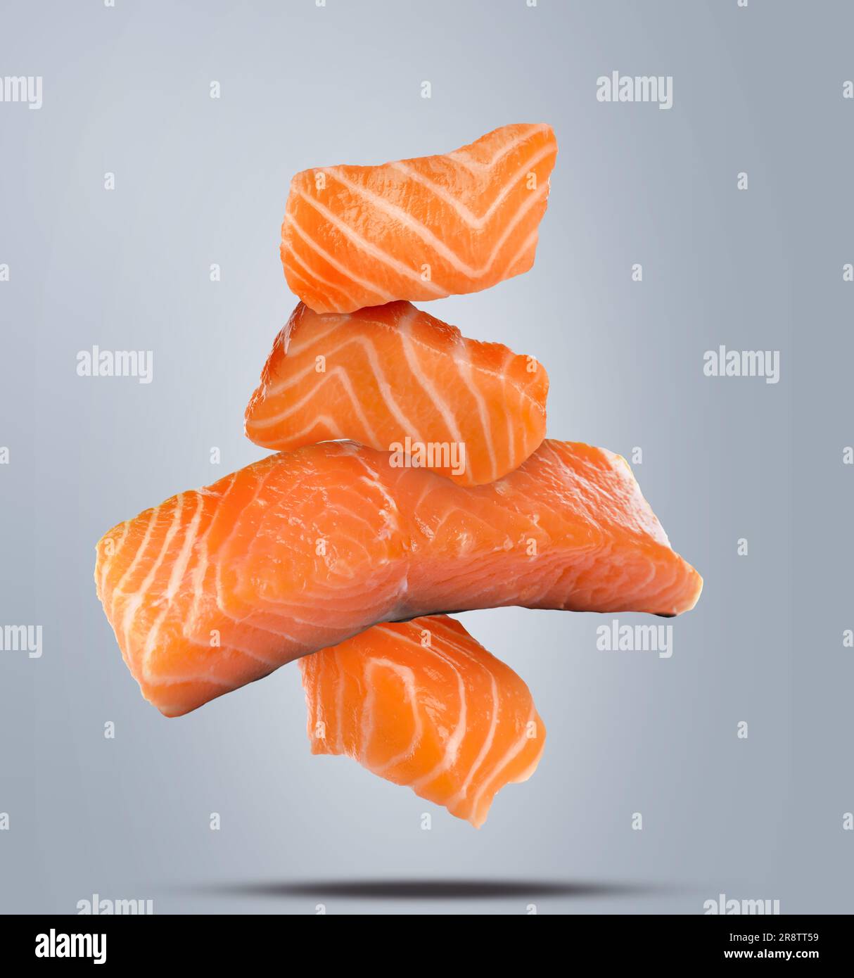 Cut fresh salmon falling on light grey background Stock Photo - Alamy