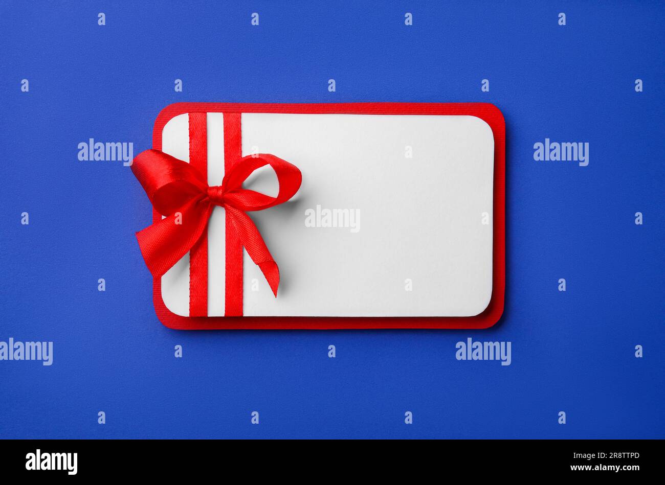 Blank gift card with red bow on blue background, top view Stock Photo ...