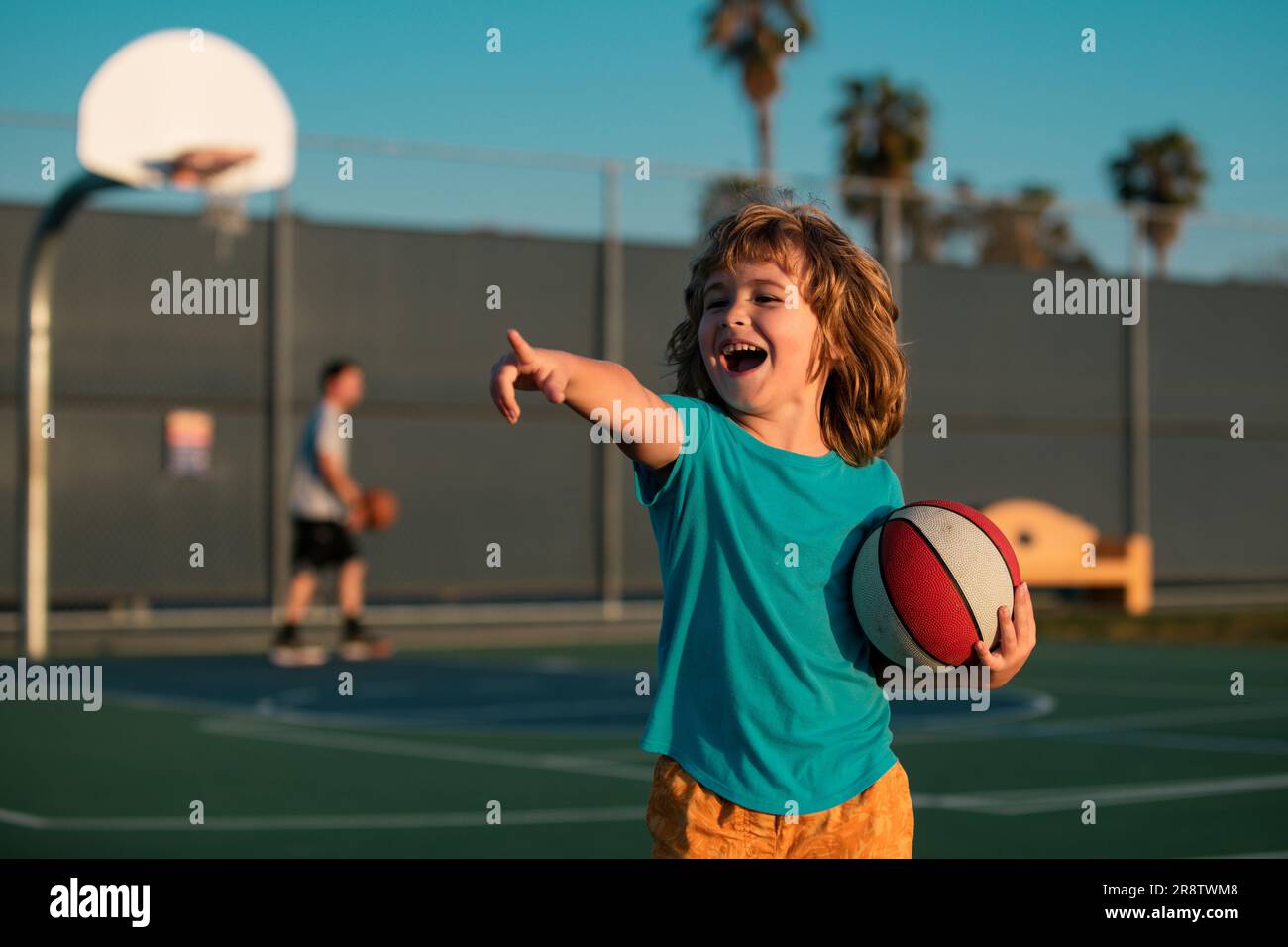 Basketball kids game. Cute little boy laughing and holding a basketball ...