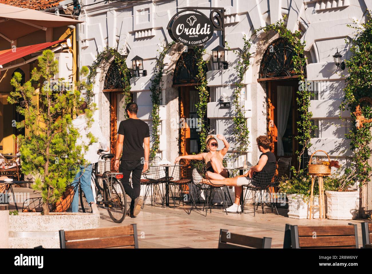 Tourists relax in front of Oraldi pastry and coffee shop on Rruga Kolë ...