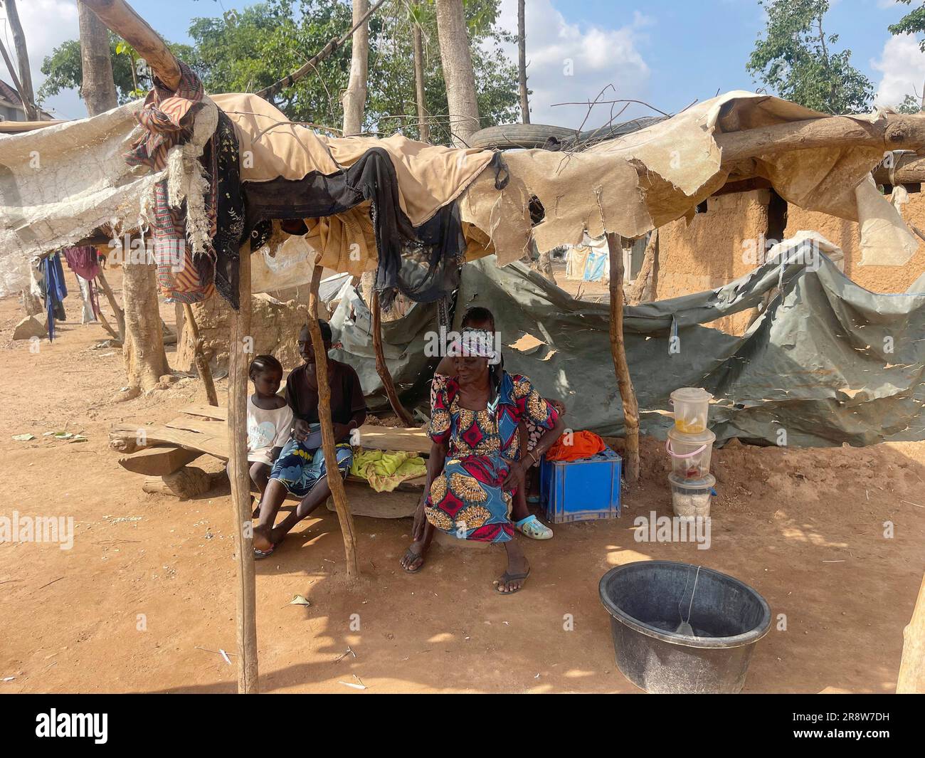Rifkatu Andruwus, 66, sits with family members, in front of her ...