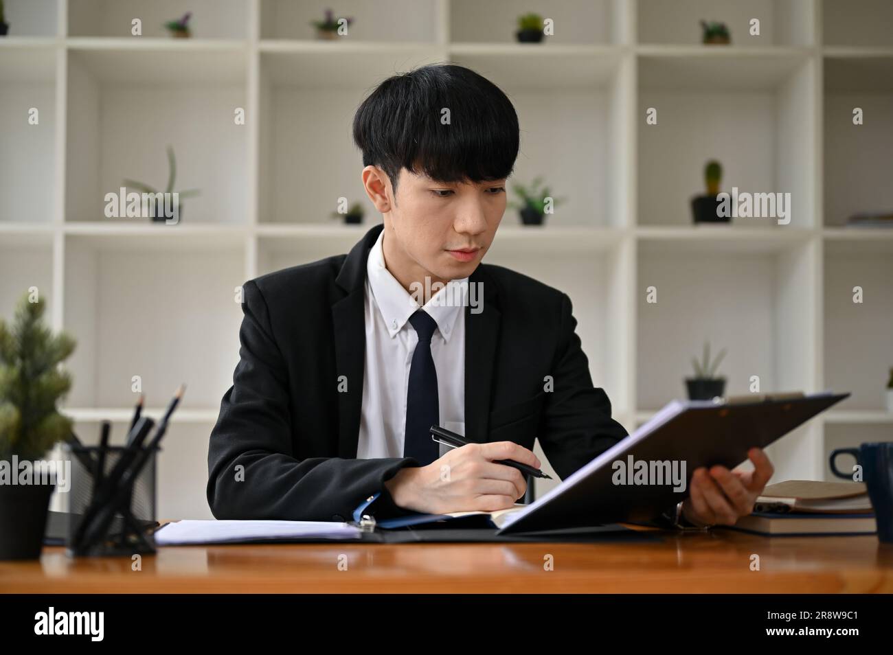 A professional and handsome Asian male lawyer in a formal suit is ...