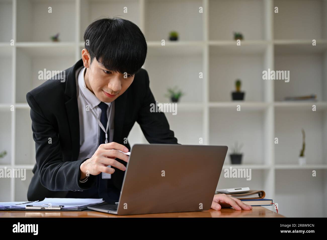A determined and confident young Asian businessman in a formal business ...