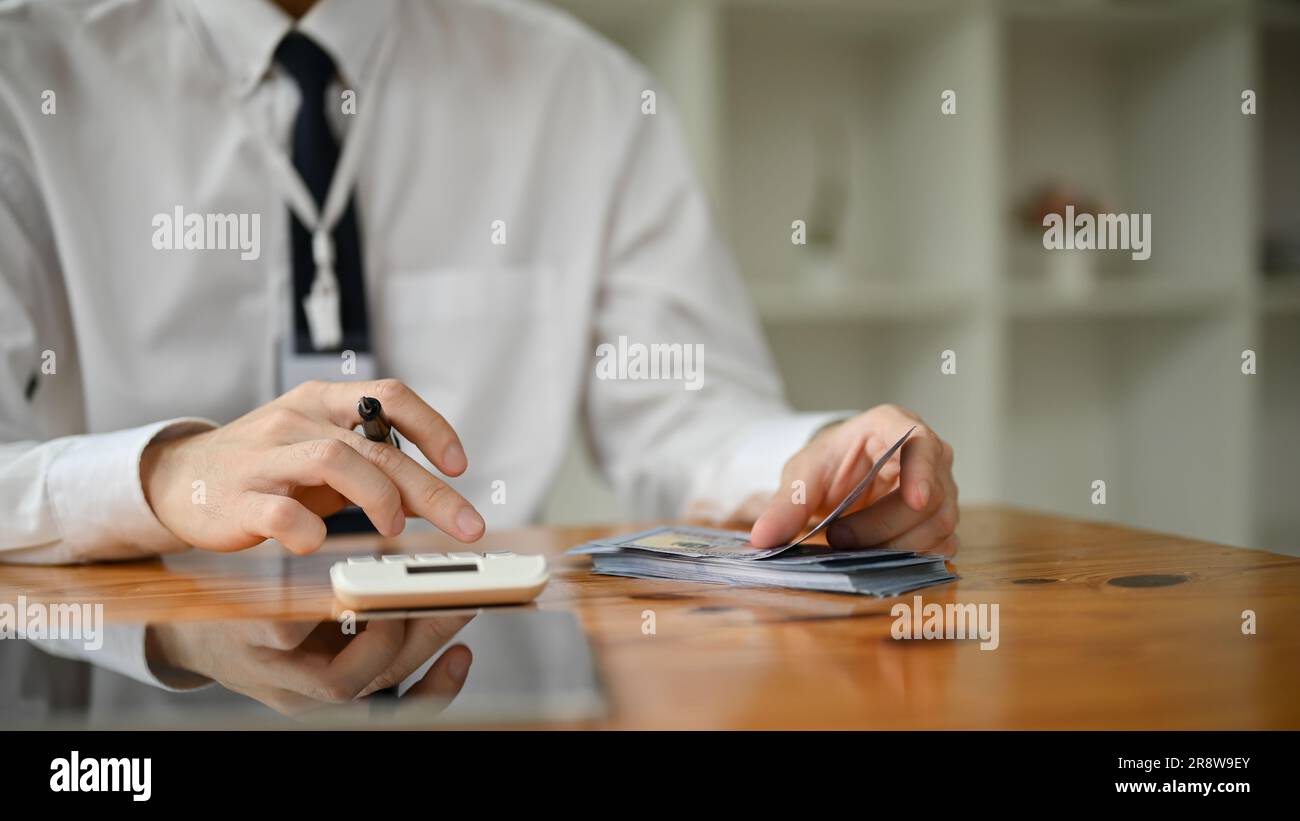 Close-up image of a professional Asian male banker using a calculator ...