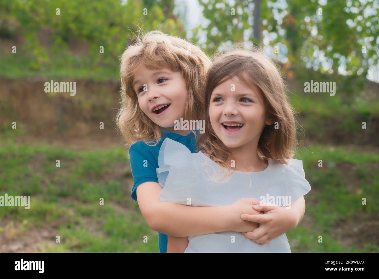 Child boy and girl hugging each other with love in the spring garden ...