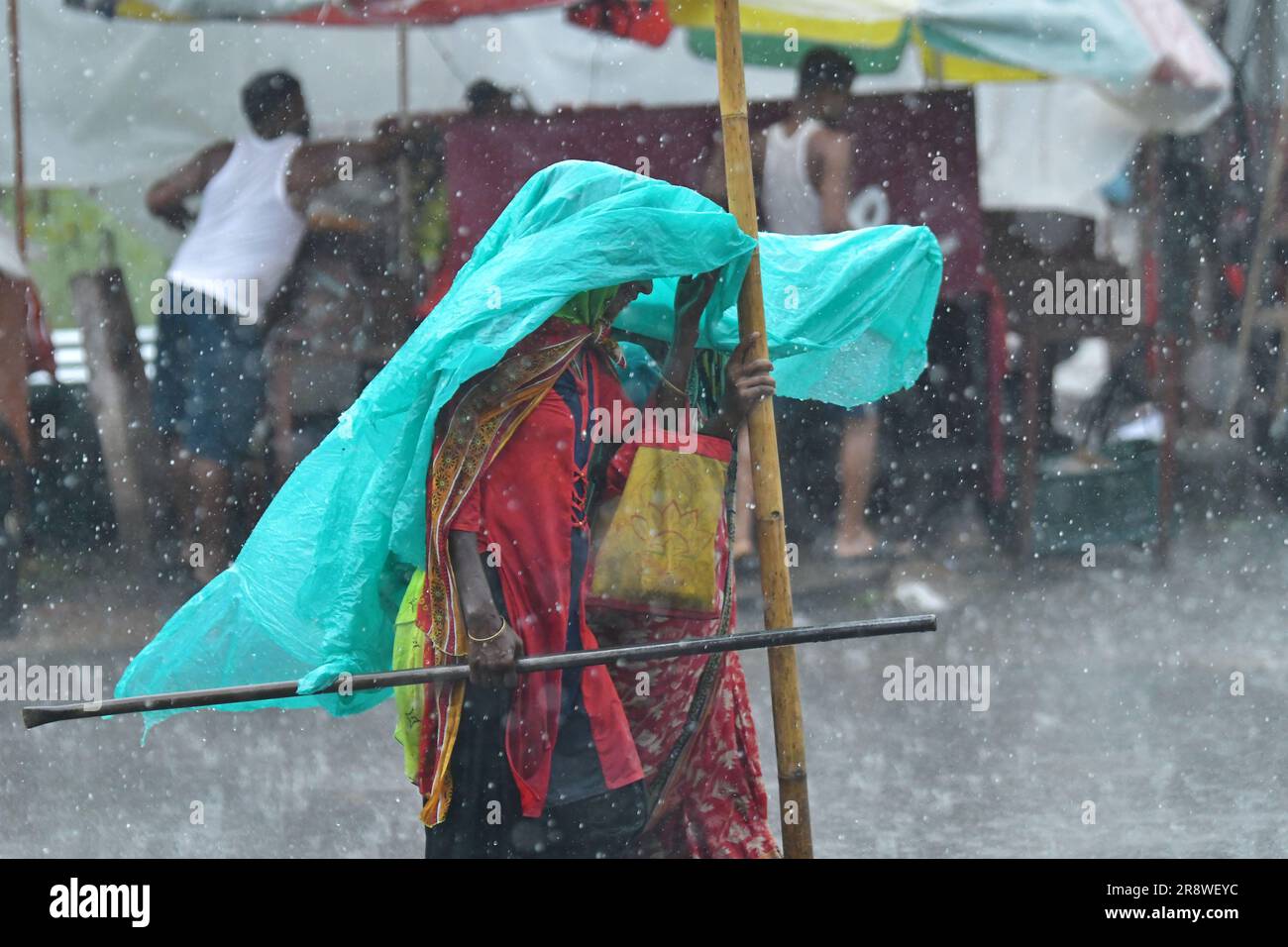 Commuters make their way on a waterlogged street during heavy rains in ...