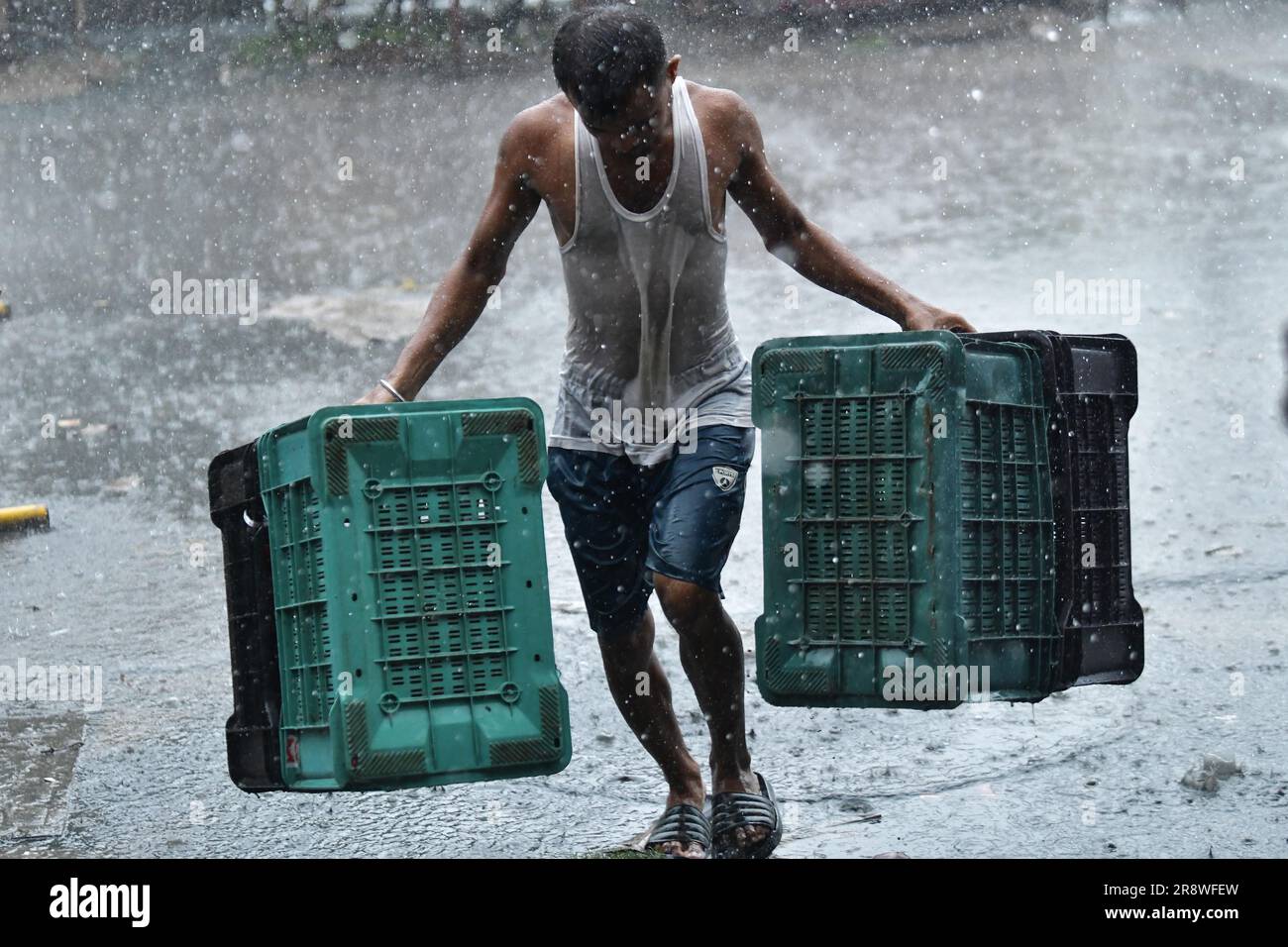 Commuters make their way on a waterlogged street during heavy rains in ...