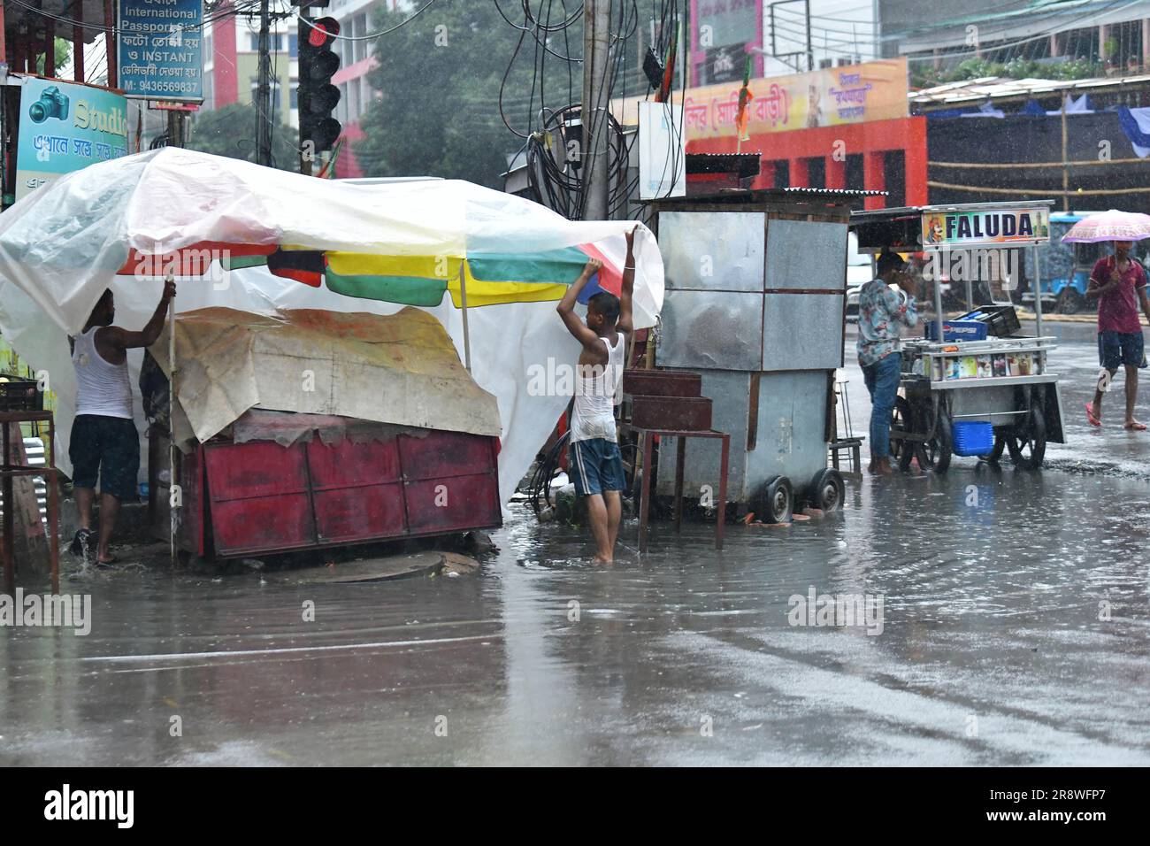 Shop keepers arranging their shop during heavy rains in Agartala ...