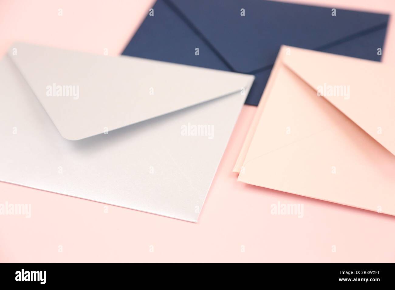 pink, blue and grey open envelopes on pink background. Close up, mockup ...