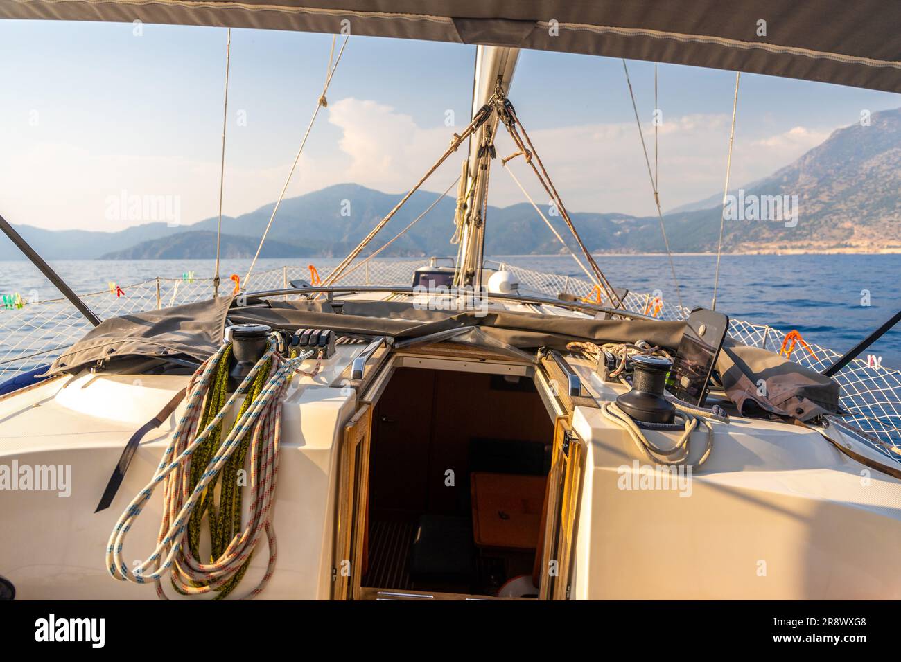 Yacht sailing in an open sea. Close-up view of the deck, mast and sails ...