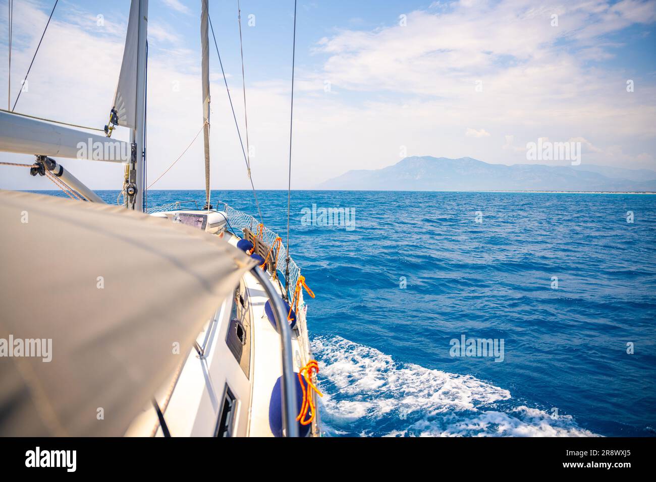 Yacht sailing in an open sea. Close-up view of side of the boat. Clear ...