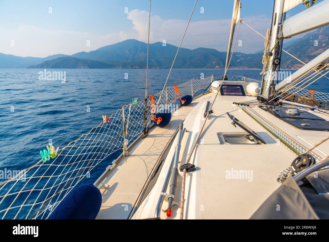 Yacht sailing in an open sea. Close-up view of the deck, mast and sails ...