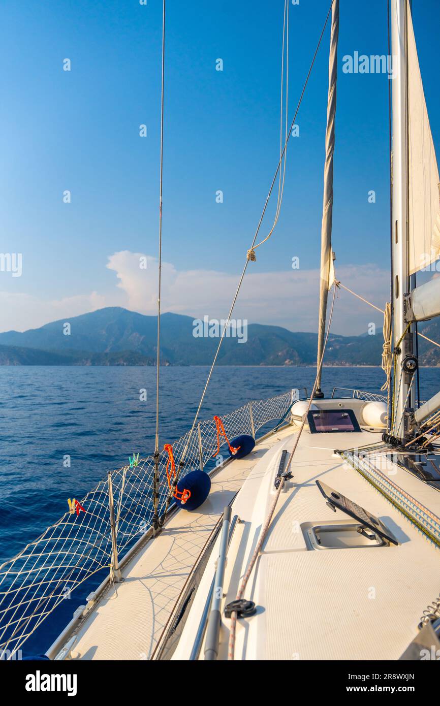 Yacht sailing in an open sea. Close-up view of the deck, mast and sails ...