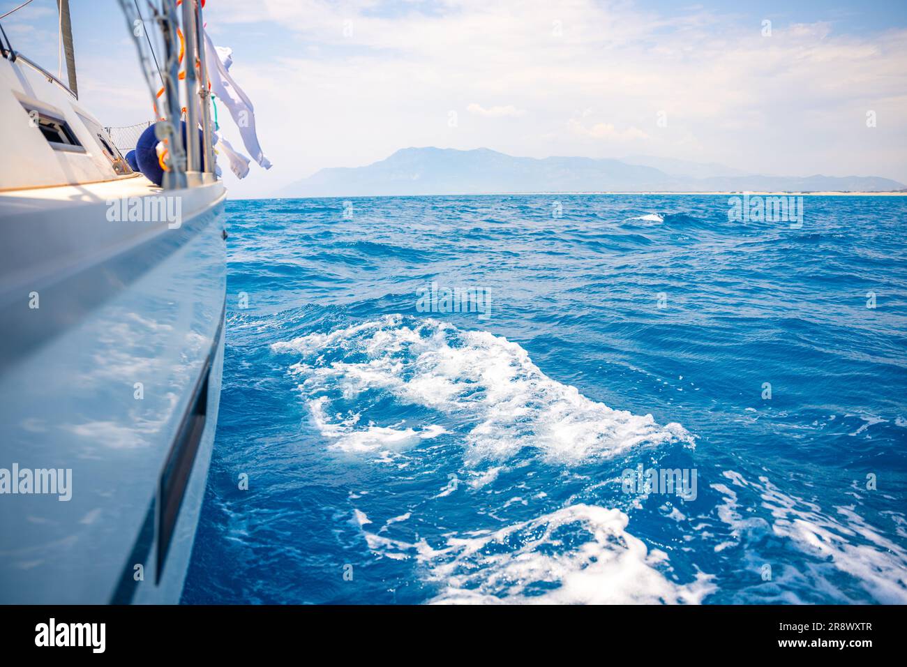 Yacht sailing in an open sea. Close-up view of side of the boat. Clear ...