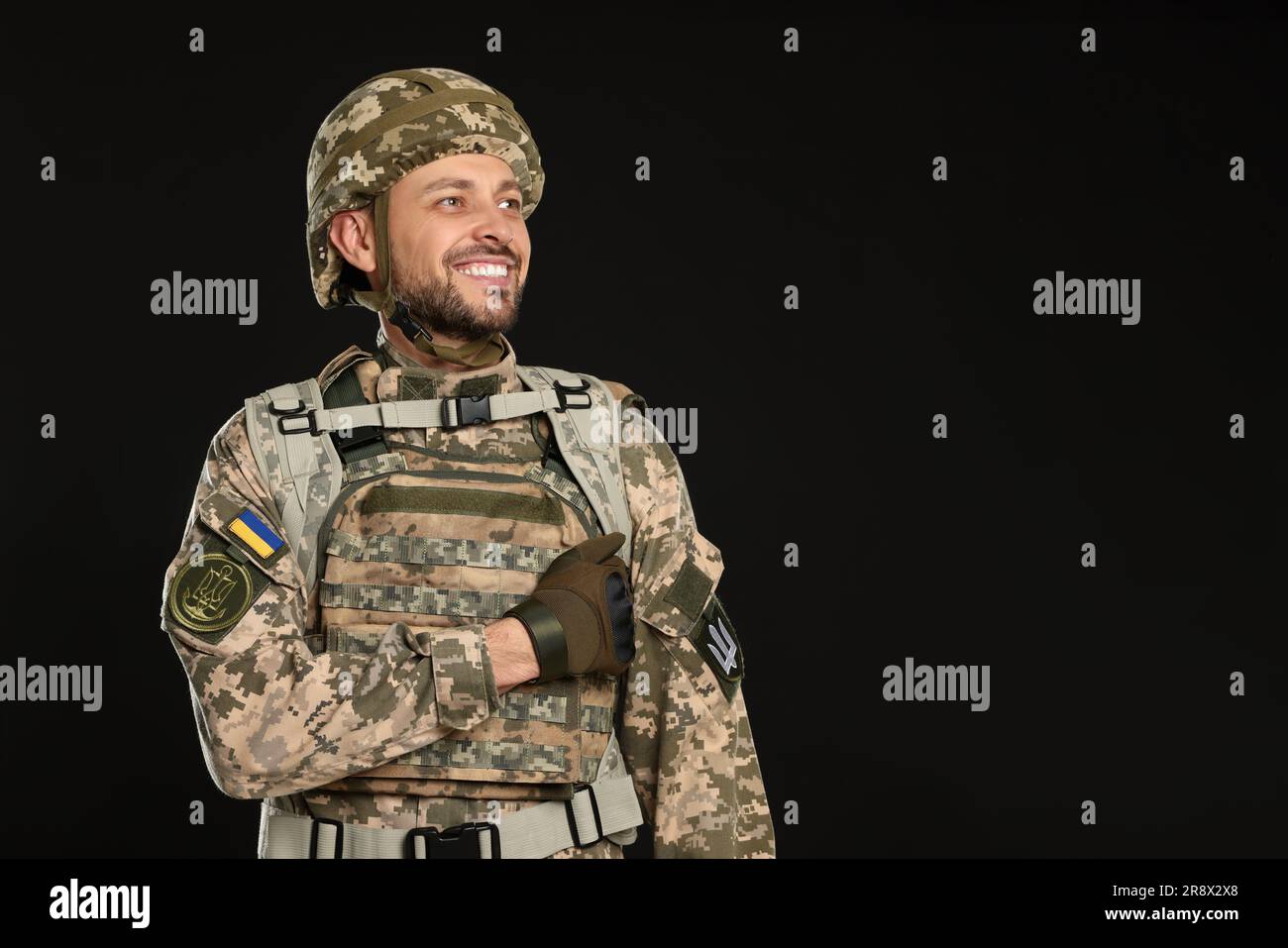 Soldier in Ukrainian military uniform on black background. Space for ...