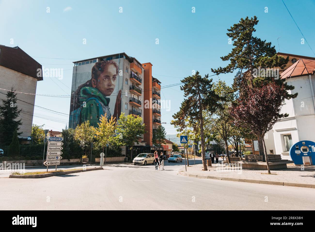 a mural of a young girl on the side of an apartment block in the city ...