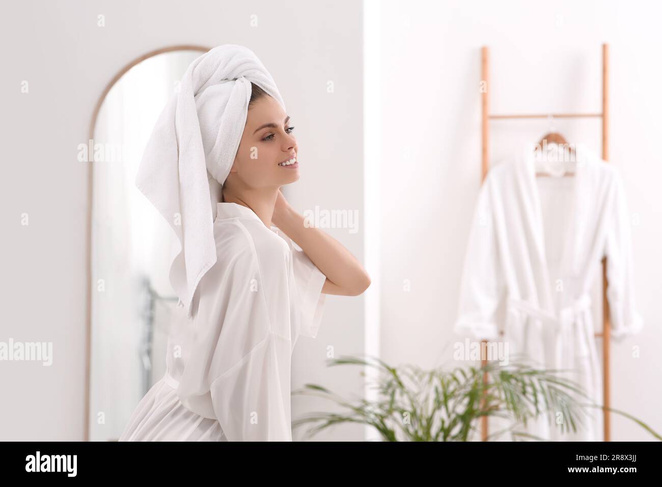 Beautiful woman wearing white robe in light bathroom Stock Photo - Alamy
