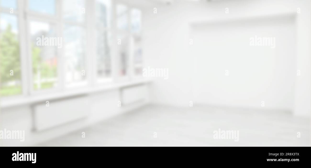 Empty room with white wall and large window, blurred view. Banner ...