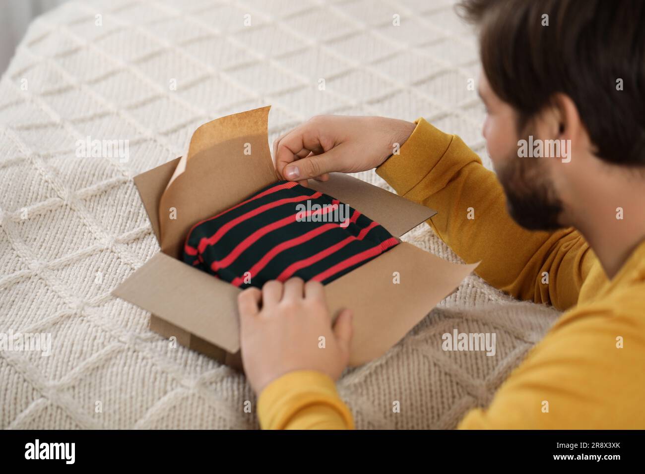 Man opening parcel at home. Internet shopping Stock Photo - Alamy