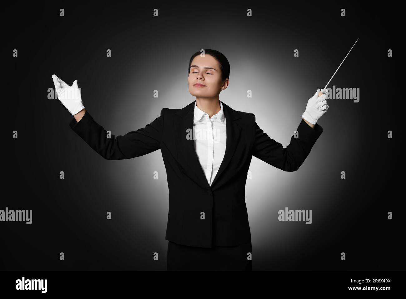 Professional conductor with baton on black background Stock Photo - Alamy