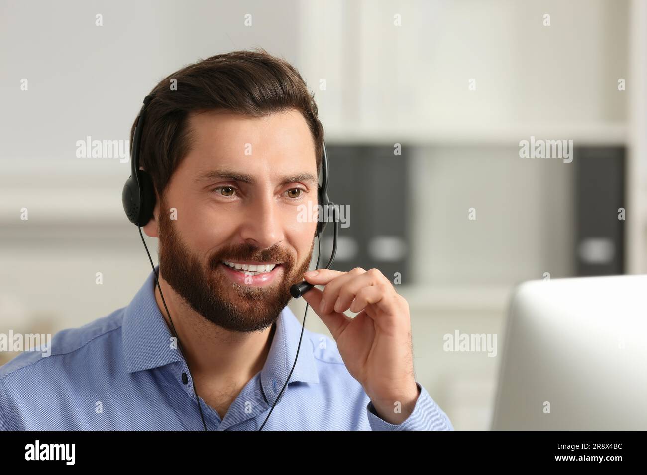 Hotline operator with headset working in office, space for text Stock ...