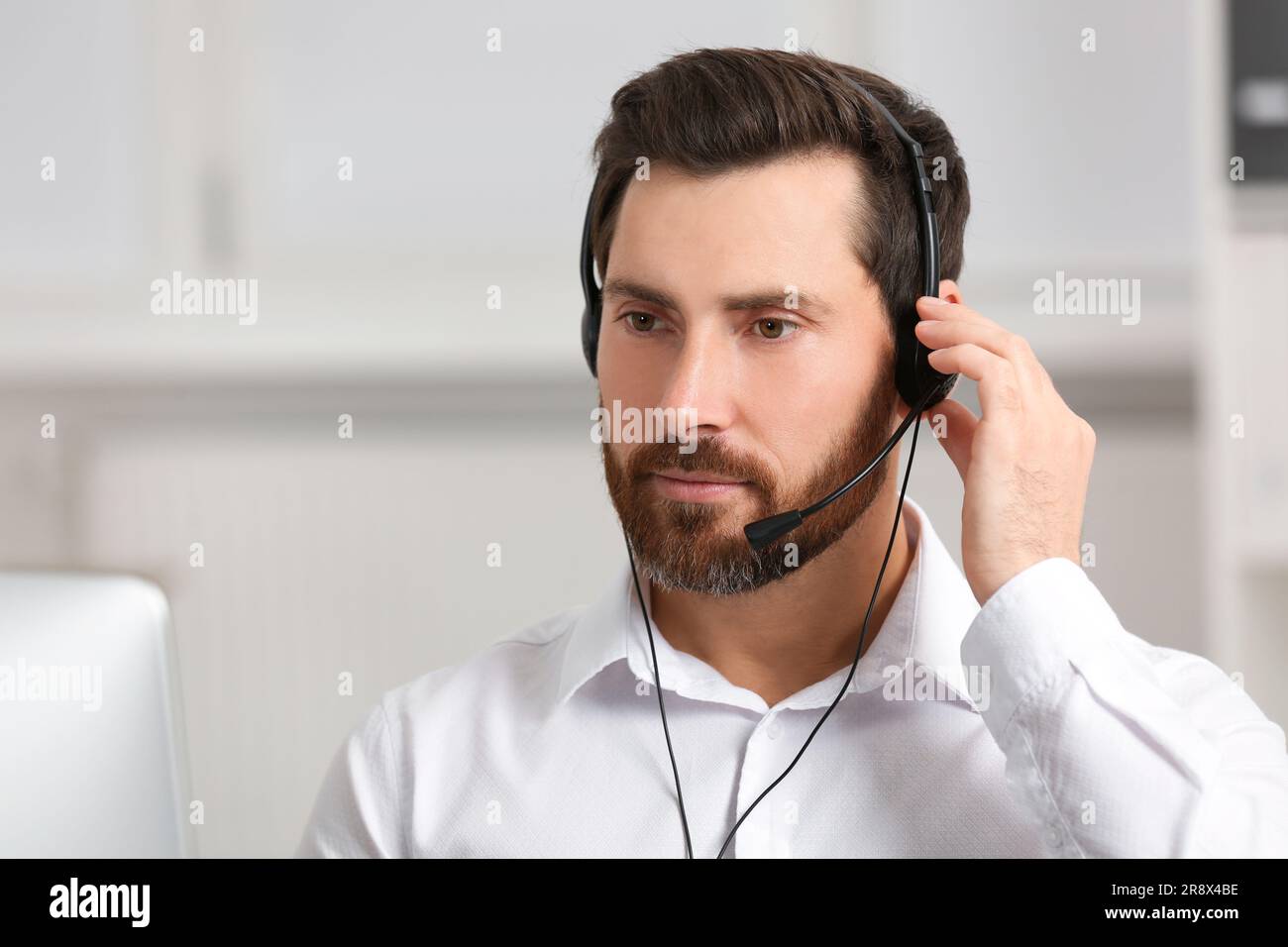 Hotline operator with headset working in office, space for text Stock ...