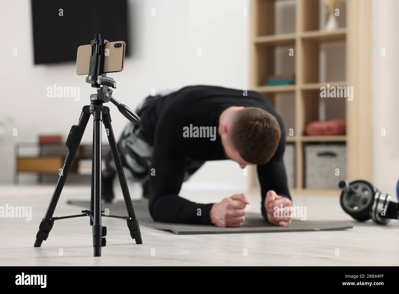Trainer streaming online workout with phone at home Stock Photo - Alamy