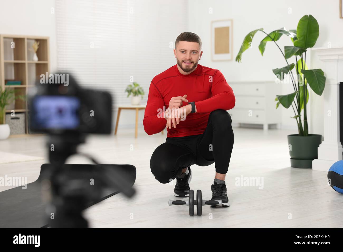 Trainer recording fitness lesson on camera at home Stock Photo - Alamy