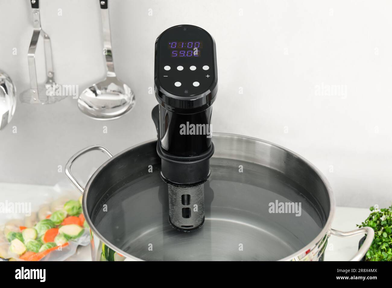 Sous vide cooker in pot on white table, closeup. Thermal immersion circulator Stock Photo - Alamy