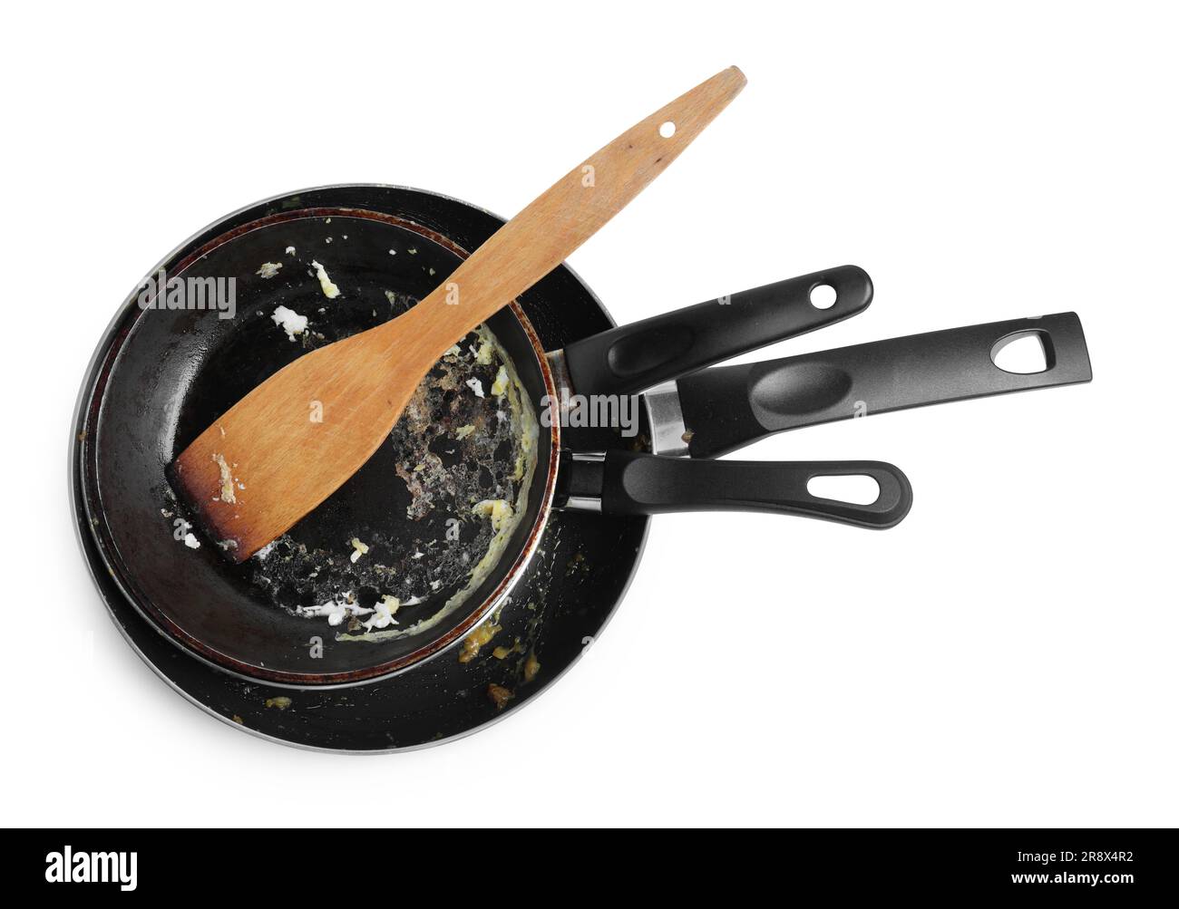 Dirty frying pans and wooden spatula on white background, top view ...