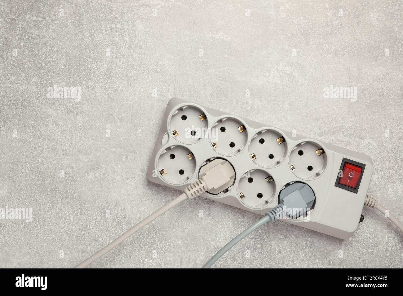Power strip with extension cord on light grey table, top view. Space ...