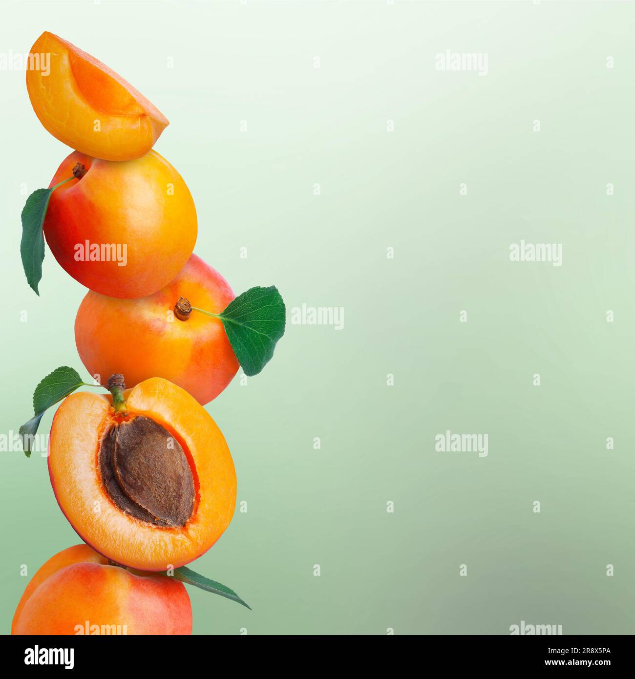 Stack of fresh ripe apricots on light green gradient background. Space ...