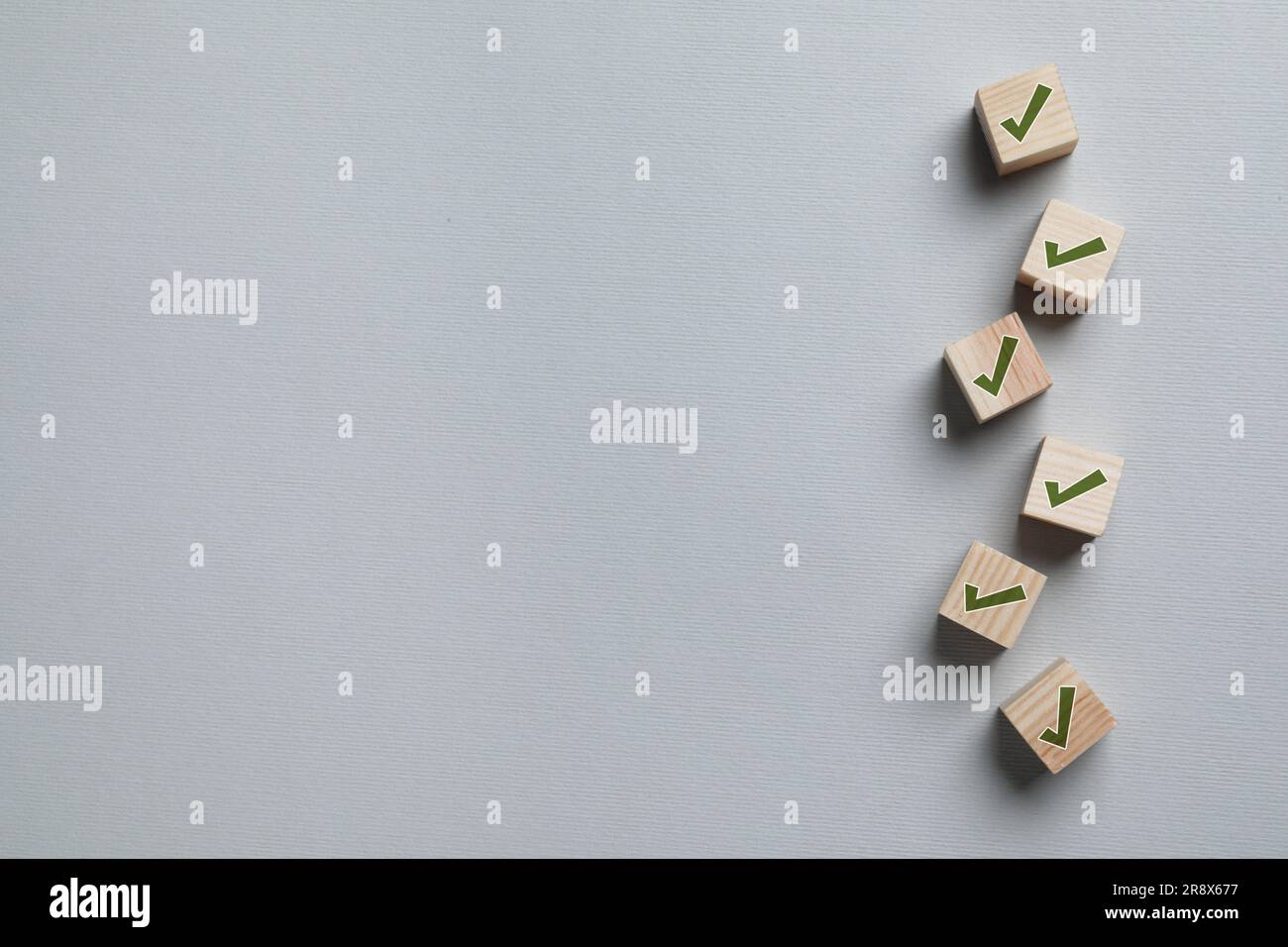 Wooden cubes with check marks on light grey background, flat lay. Space ...