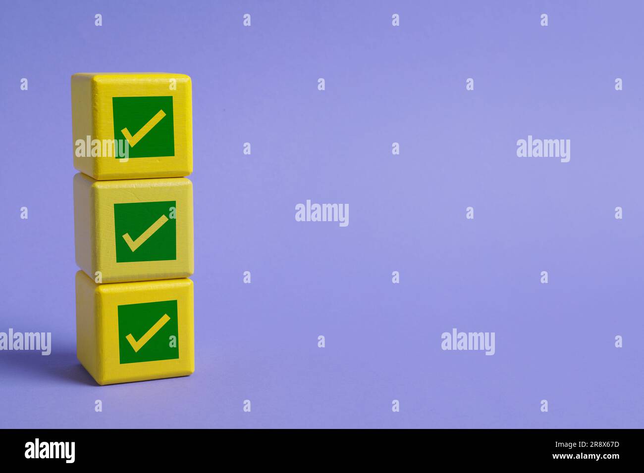 Stacked cubes with check marks on light violet background. Space for ...