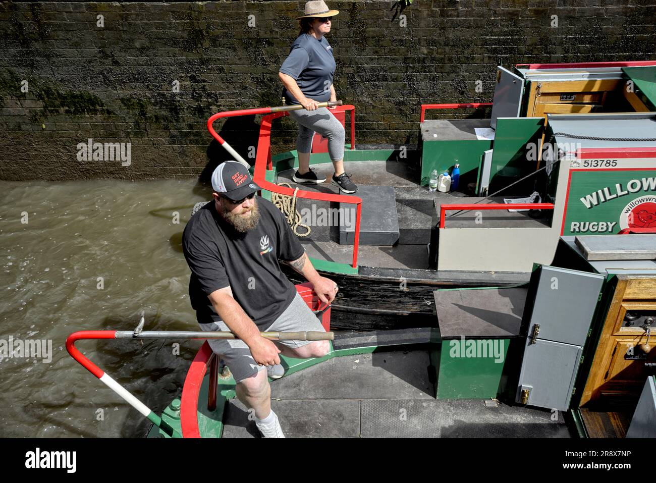 People navigating narrow boats through the locks at Hatton Locks ...