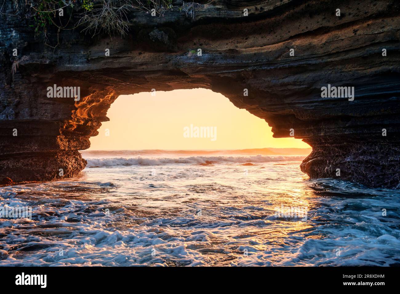 Natural rock cave formation and wave in the sunset at Pura Batu Bolong ...