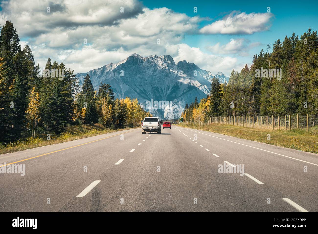 Road trip with car driving on highway to rocky mountains in autumn ...