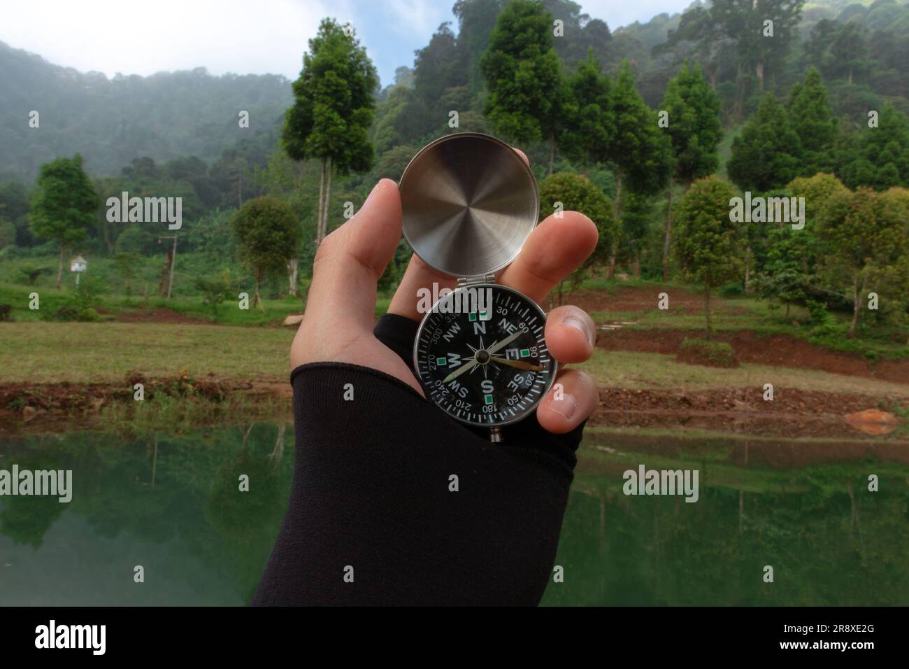 Concept for traveling and adventure. A compass held by hand, after some ...