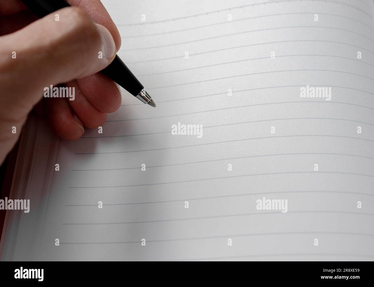 Hand holding a pen on a blank page, after some edits Stock Photo - Alamy
