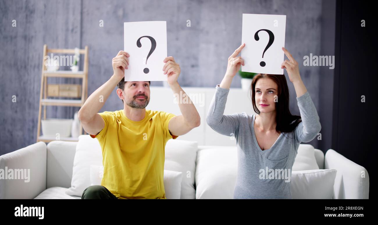 Couple In The Living Room With Question Marks Stock Photo - Alamy