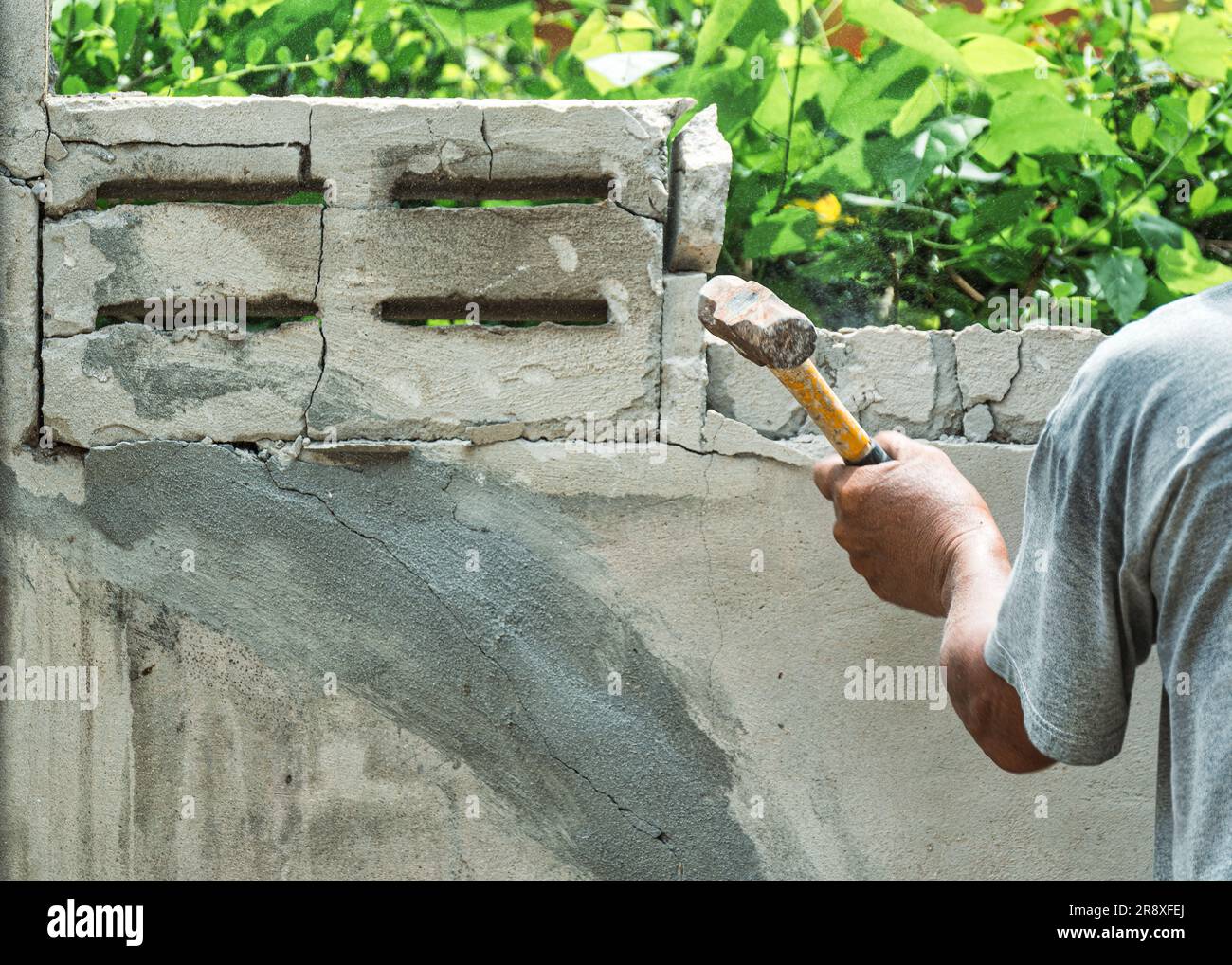Hand of worker using hammer smashing and demolish on brick block wall ...