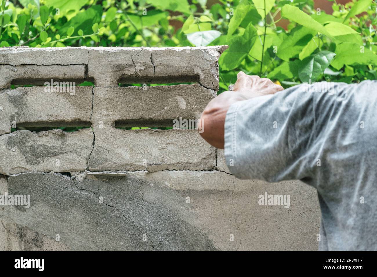 Hand of worker using hammer smashing and demolish on brick block wall ...