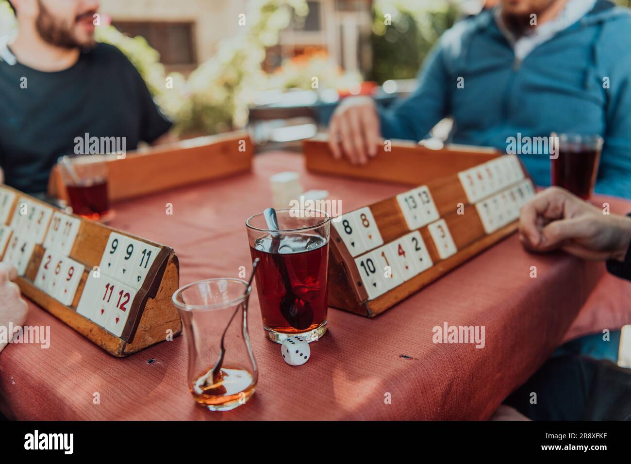 A group of men drink traditional Turkish tea and play a Turkish game ...