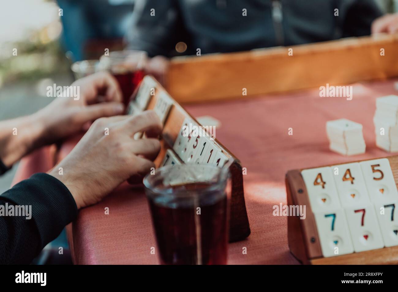 A group of men drink traditional Turkish tea and play a Turkish game ...