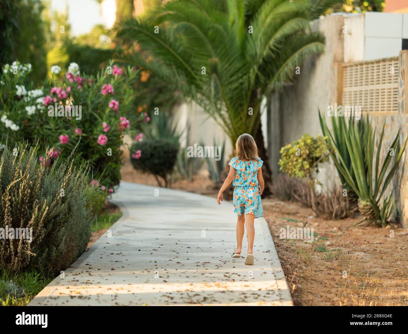 Girl running in the distance on a park path Stock Photo - Alamy