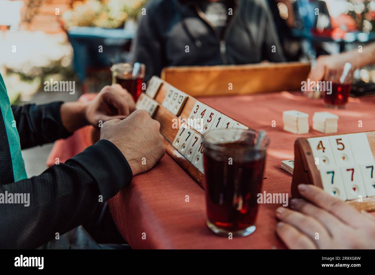 A group of men drink traditional Turkish tea and play a Turkish game ...